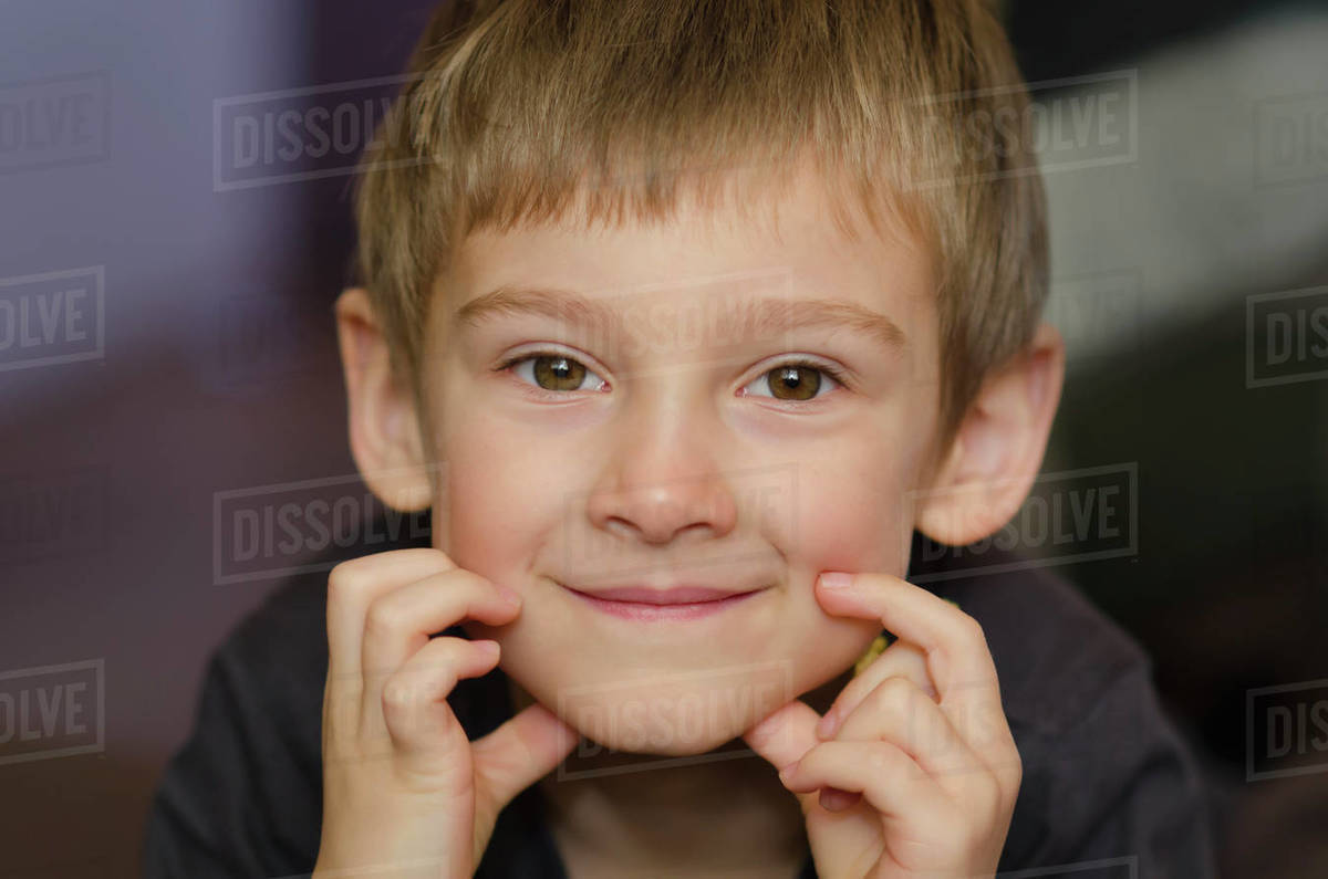Portrait of a smiling boy with hands on his chin - Royalty-free Stock ...