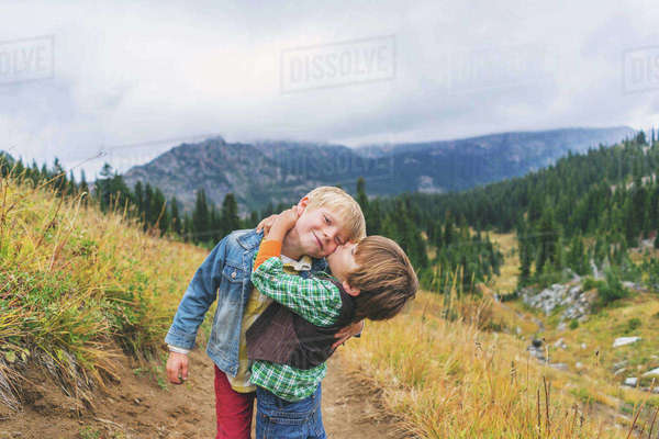 Two brothers hugging and kissing on mountain path - Royalty-free Stock ...