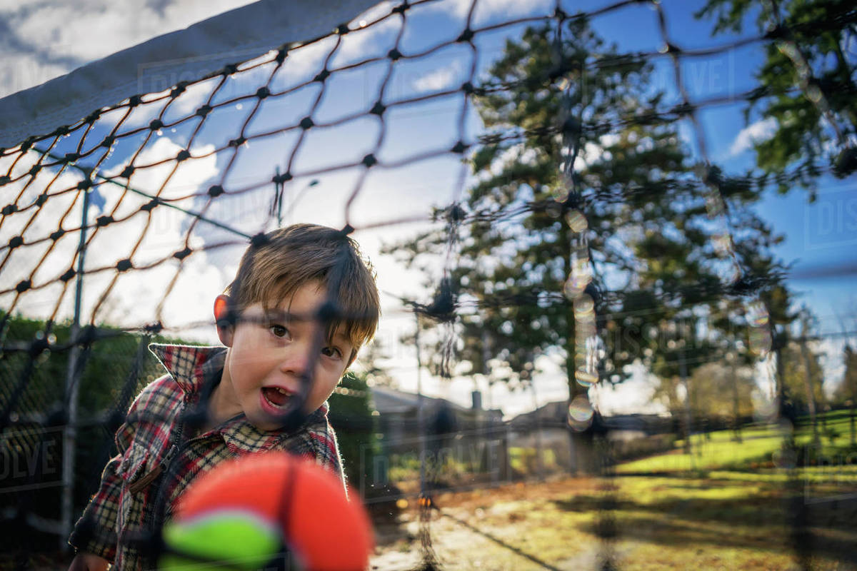 View through a net of a boy throwing tennis ball - Royalty-free Stock ...