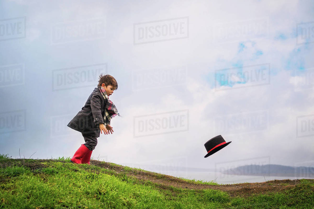 Boy chasing his hat blowing away in the wind - Royalty-free Stock Photo ...