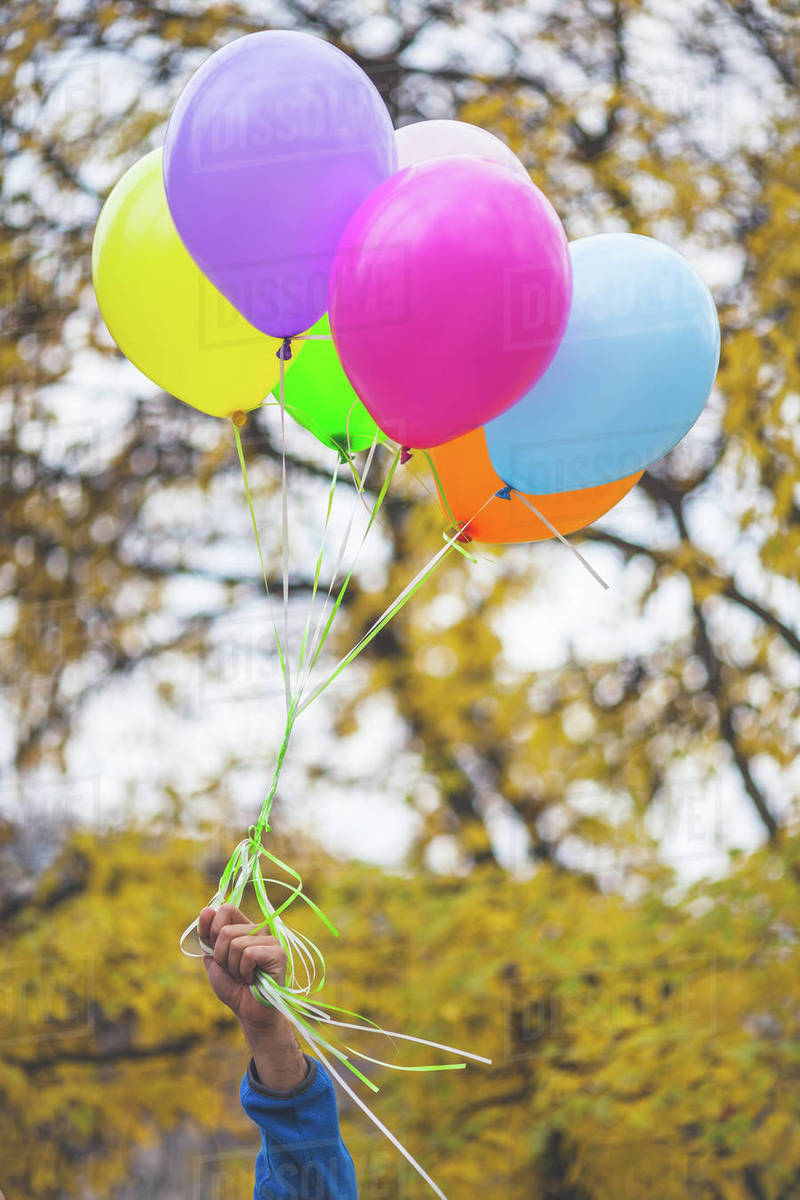 Man's hand holding balloons - Royalty-free Stock Photo | Dissolve