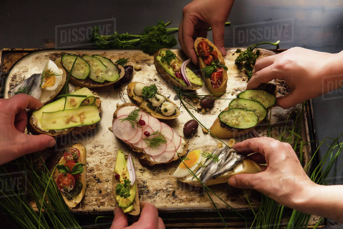Four people eating open sandwiches - Royalty-free Stock Photo | Dissolve