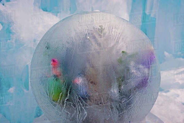 Frozen ice ball filled with colorful objects - Stock Photo - Dissolve