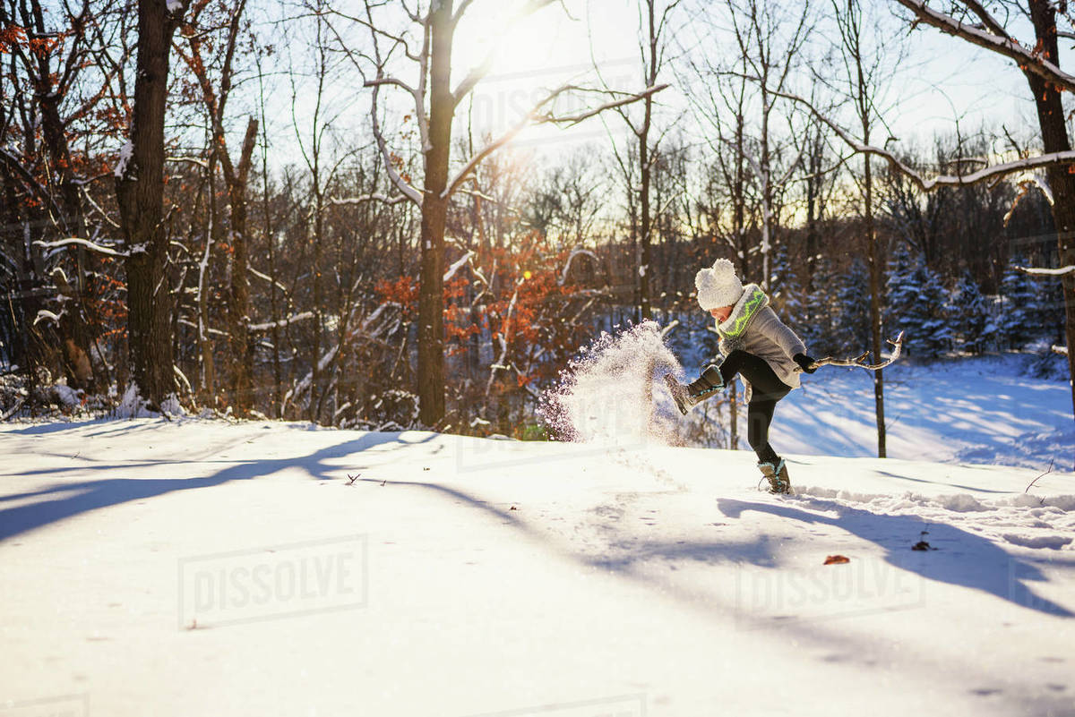 Girl kicking snow - Stock Photo - Dissolve