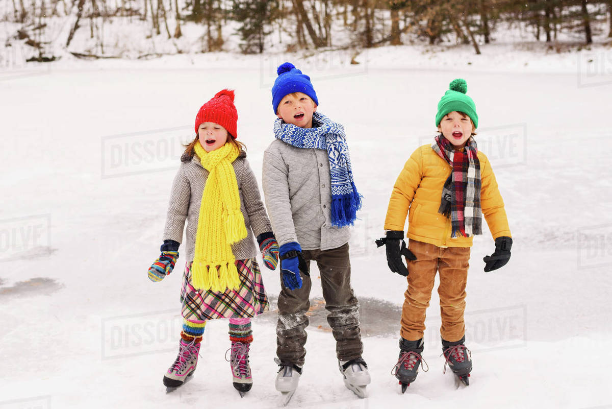 Three children on ice skates singing carols - Royalty-free Stock Photo ...