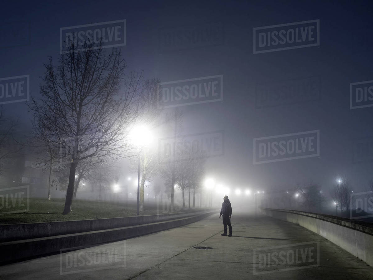 Man standing in street at night - Royalty-free Stock Photo | Dissolve
