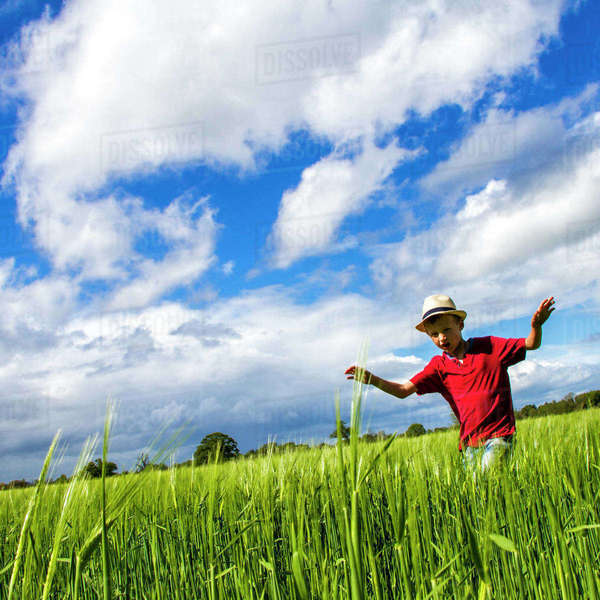 Boy running through field - Royalty-free Stock Photo | Dissolve