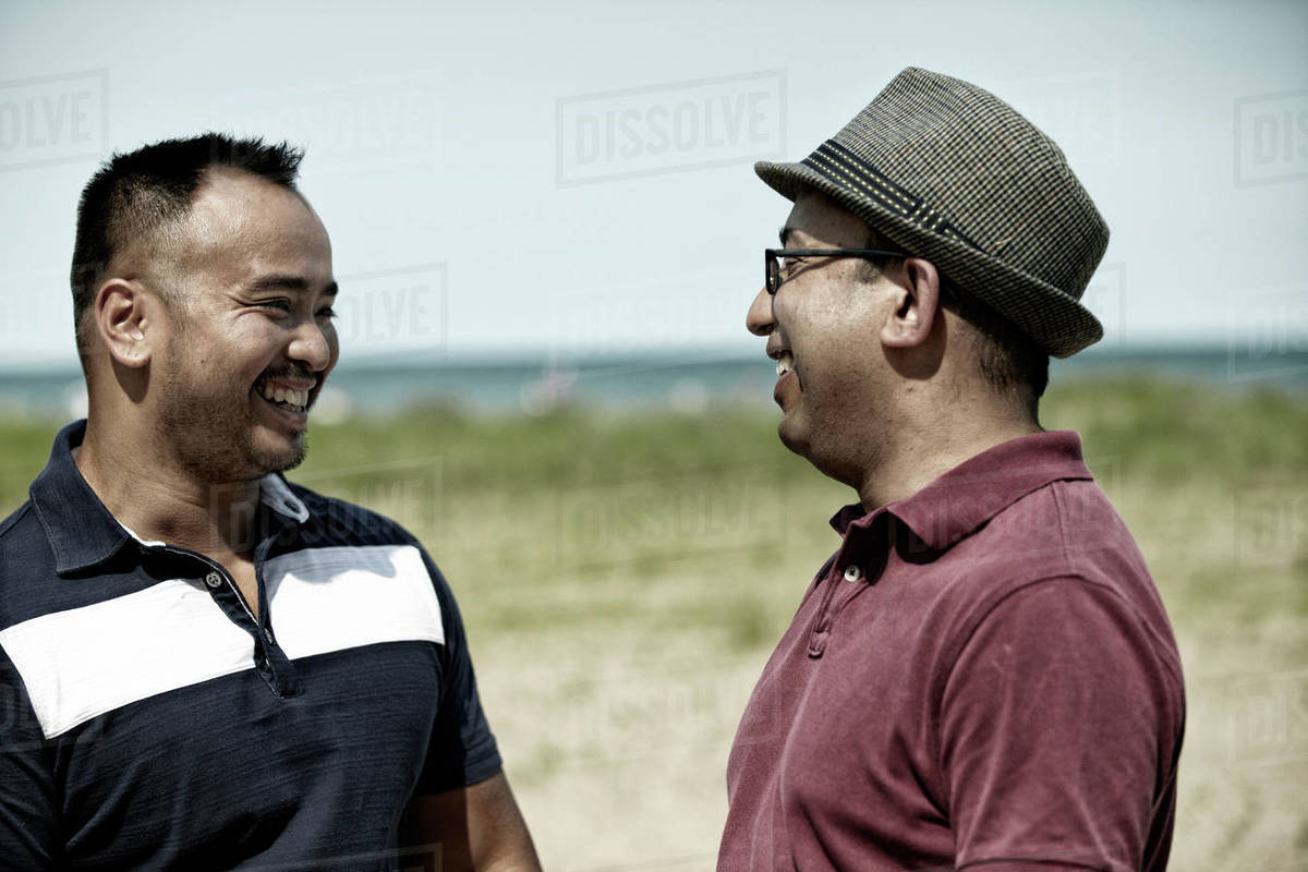 Portrait of two men talking on beach, Chicago, Illinois, America, USA ...