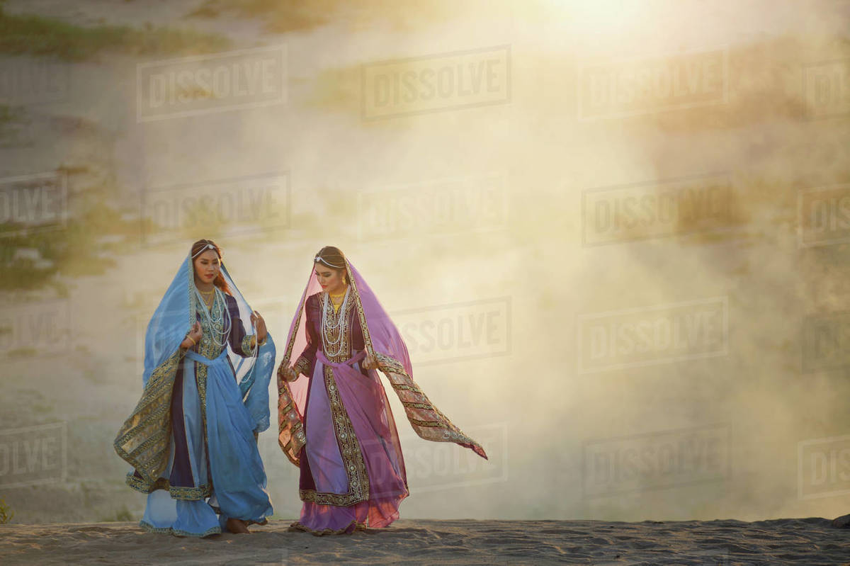Two beautiful women wearing traditional middle eastern clothing ...