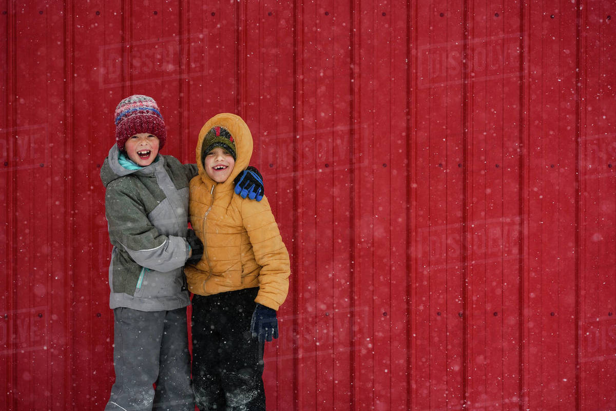 Two happy children messing about in front of a red house, USA - Royalty ...