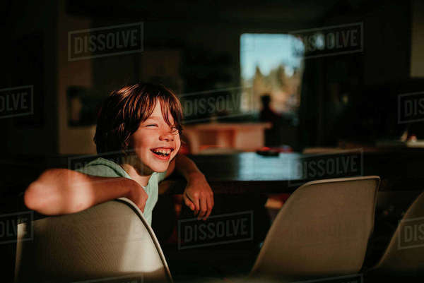 Happy boy sitting at a dining room table - Royalty-free Stock Photo ...