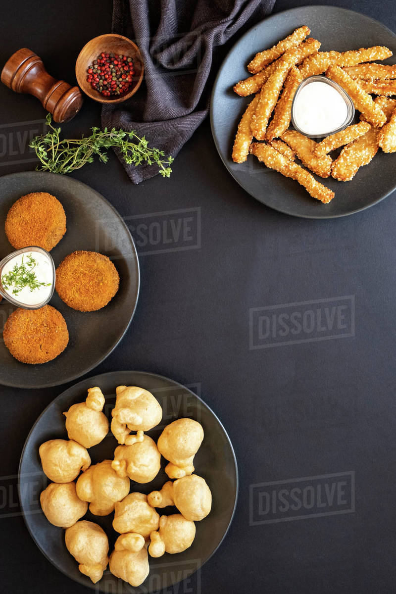 Assorted fried appetizer selection on a table - Stock Photo - Dissolve