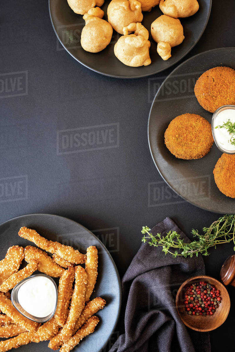Assorted fried appetizer selection on a table - Stock Photo - Dissolve