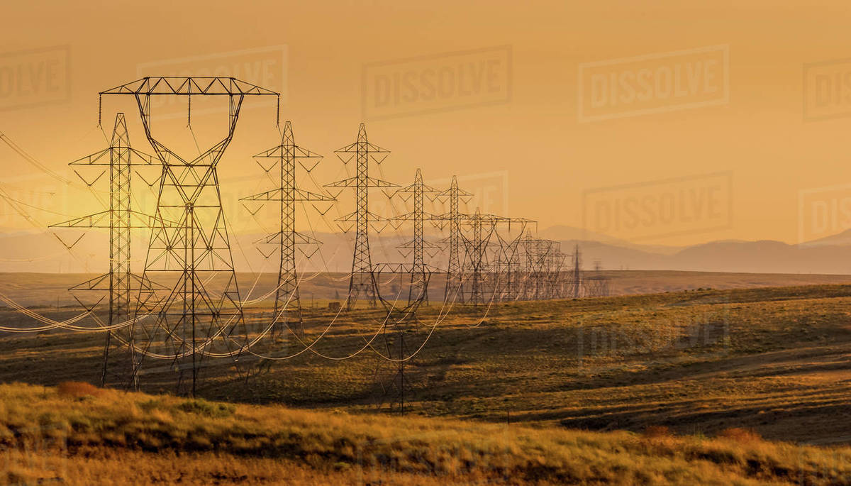 Electrical power lines through a rural landscape at sunset, USA ...