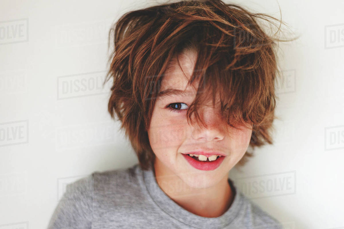 Portrait of a smiling boy with messy hair - Stock Photo - Dissolve