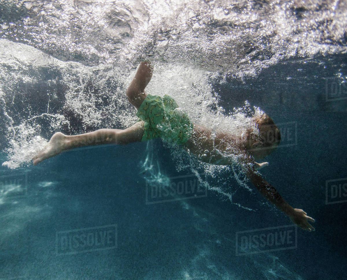 Boy diving into a swimming pool - Stock Photo - Dissolve