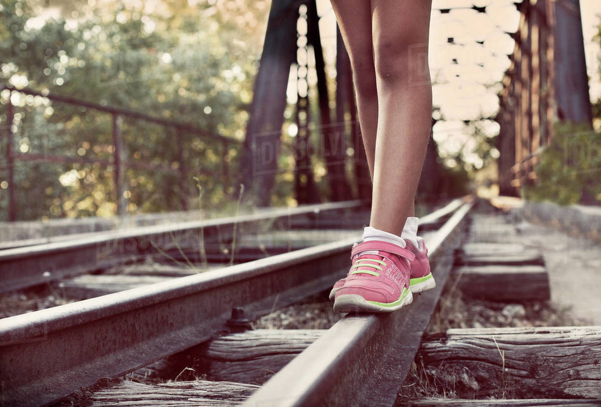 Close-up of woman's legs walking along train tracks - Royalty-free ...