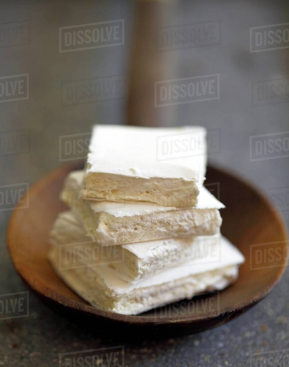 Square pieces of white, plain nougat in stack on wooden spoon - Stock ...