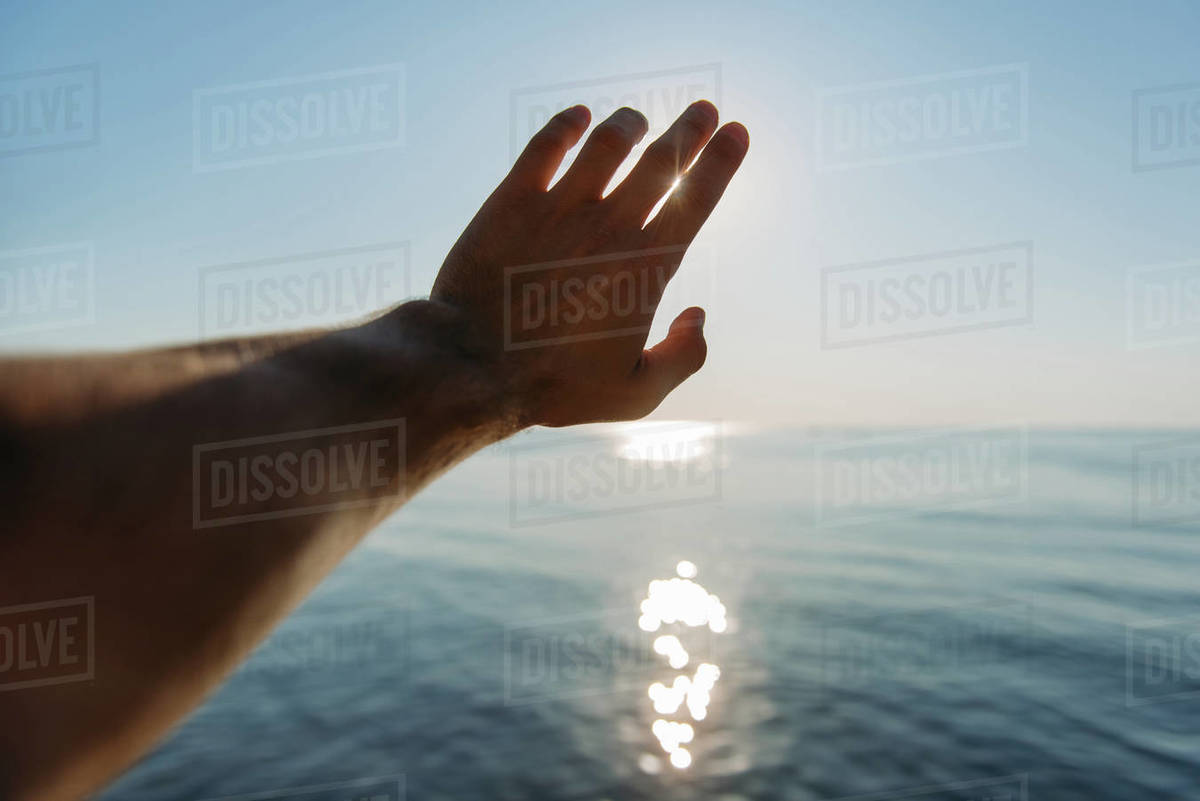 Man's hand reaching for the sun - Royalty-free Stock Photo | Dissolve