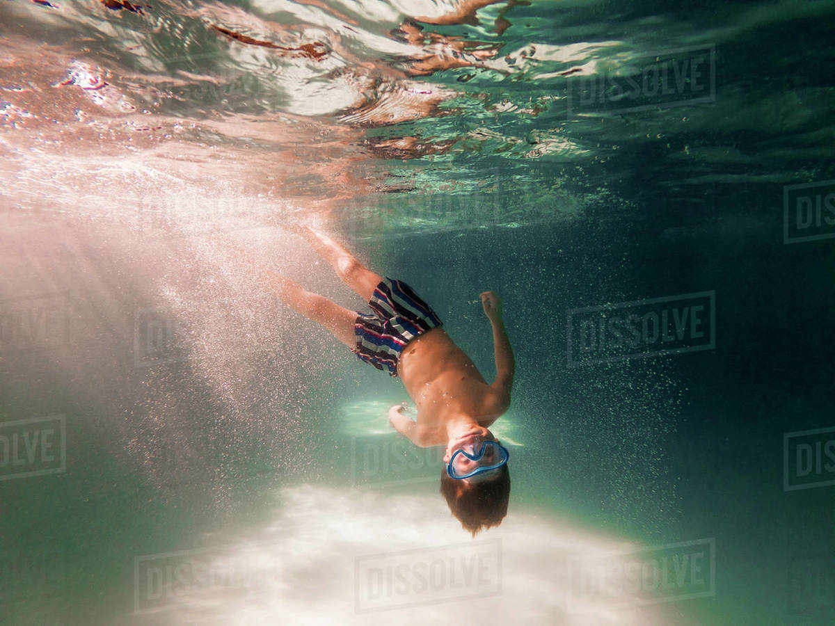 Boy diving into a swimming pool - Stock Photo - Dissolve