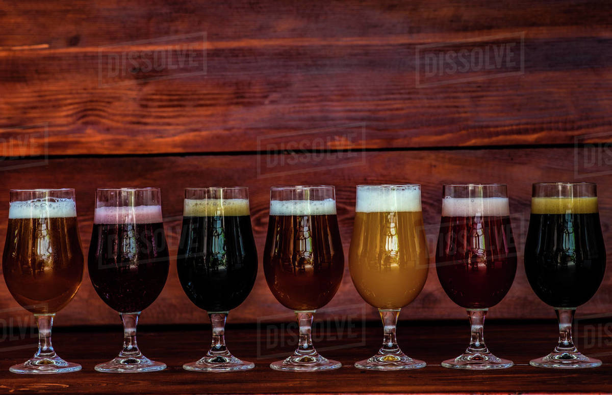 A row of assorted craft beers lined up on a table - Stock Photo - Dissolve