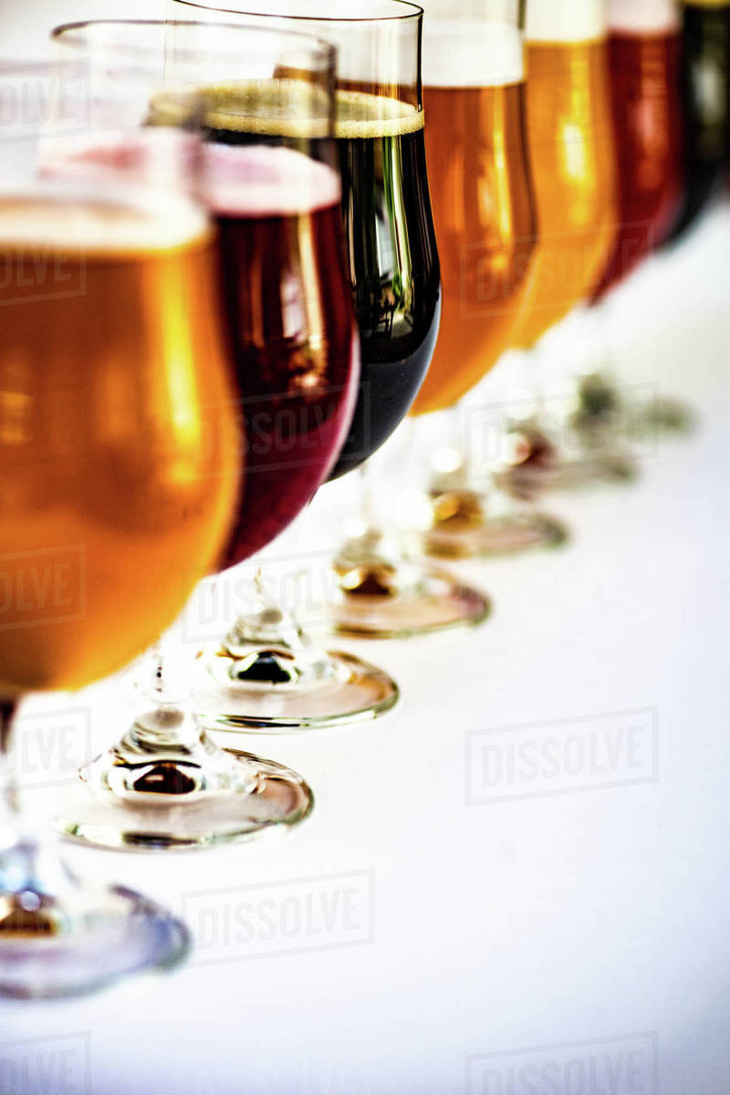 A row of assorted craft beers lined up on a table - Stock Photo - Dissolve