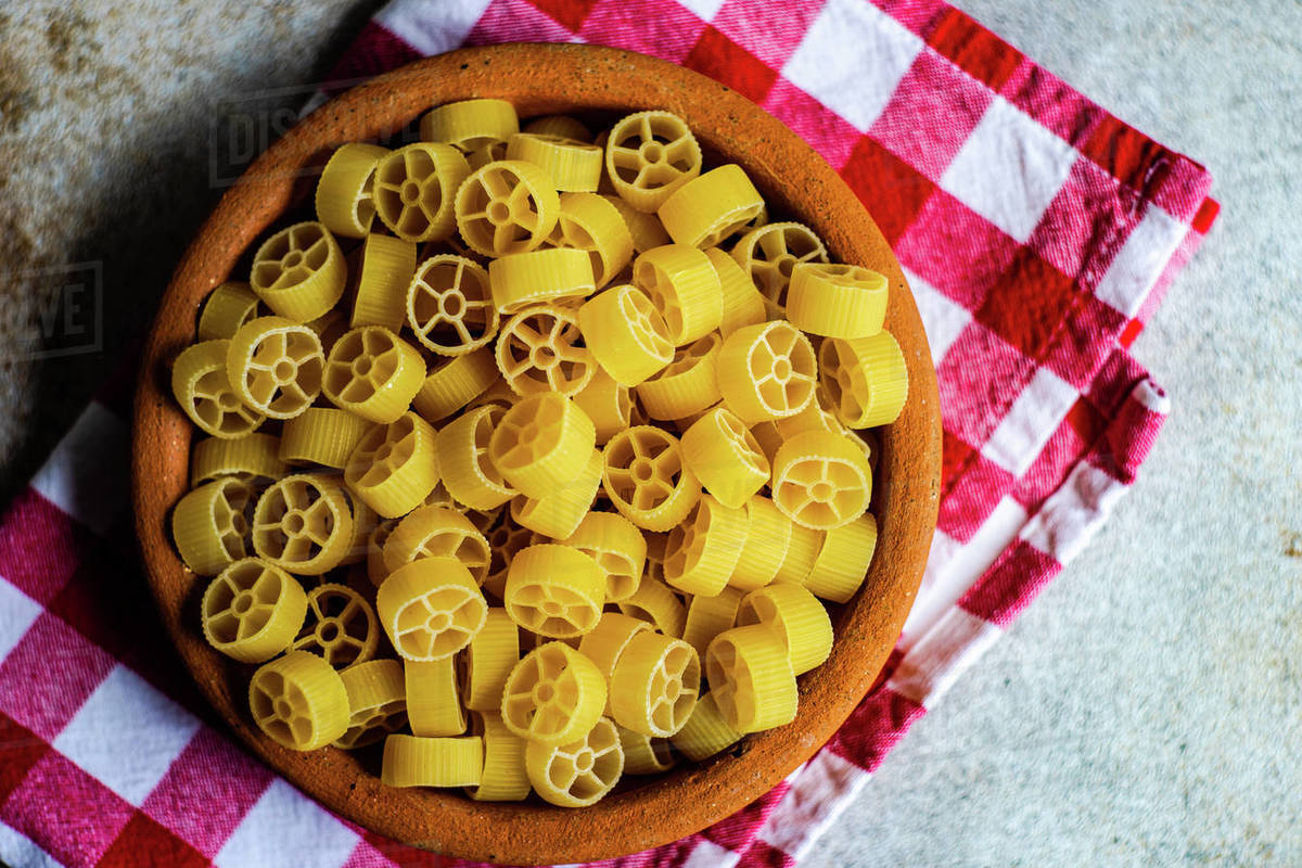 Overhead view of a bowl of ruote pasta on a folded napkin - Stock Photo ...