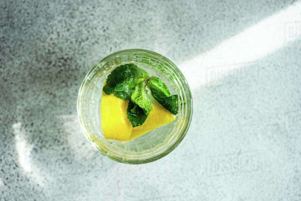 Overhead view of a glass of lemon water with mint - Stock Photo - Dissolve