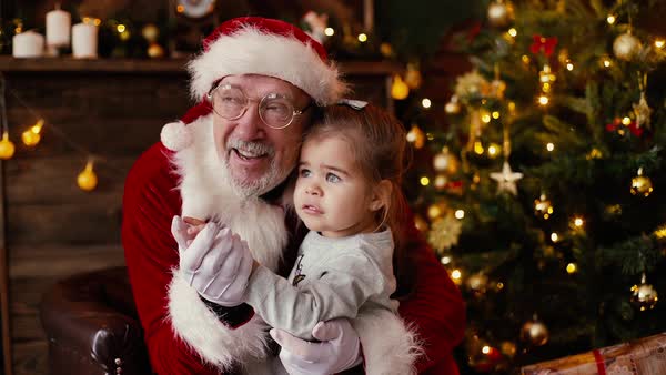 Little girl whispering Santa Claus ear her christmas wish sitting on ...
