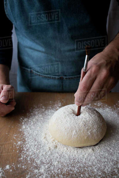 Unrecognizable cook shaping fresh dough with flour while cooking Rosca ...
