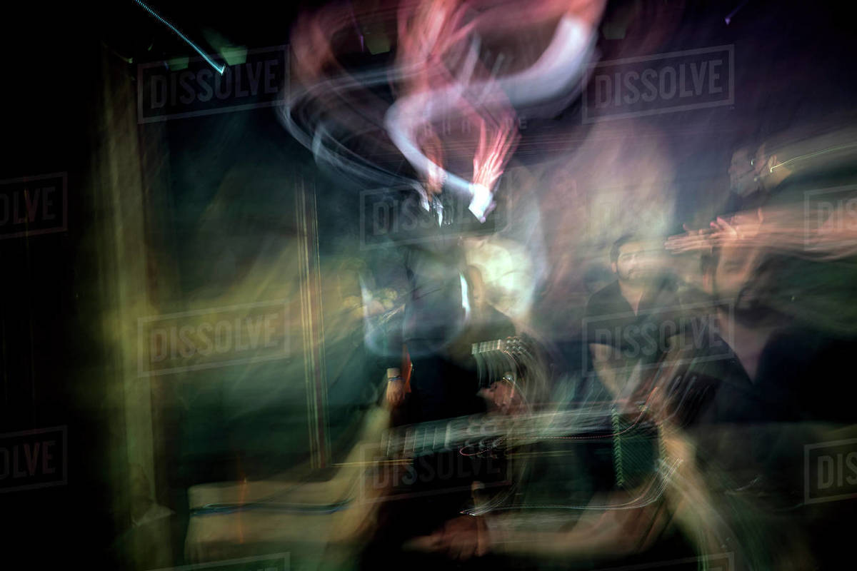 man in black costume dancing flamenco near Hispanic male musicians ...