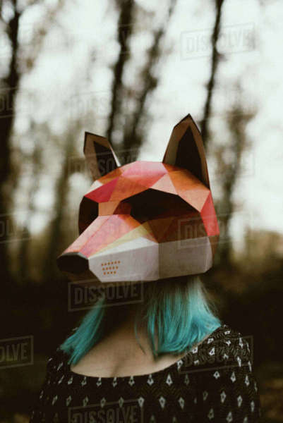 Anonymous female in paper fox mask walking in mysterious autumn forest ...