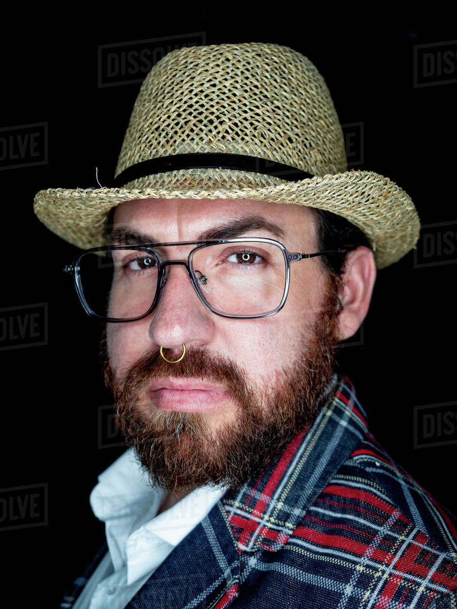 Handsome bearded man in glasses and looking at camera on black ...