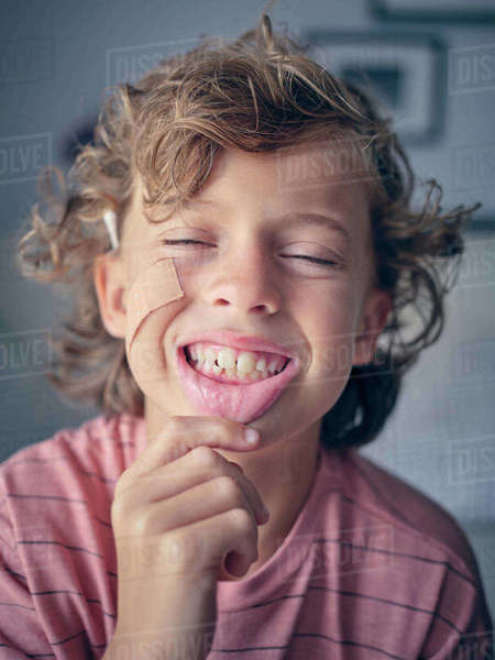 Unsteady baby tooth in wide open mouth of anonymous child pulling lip ...