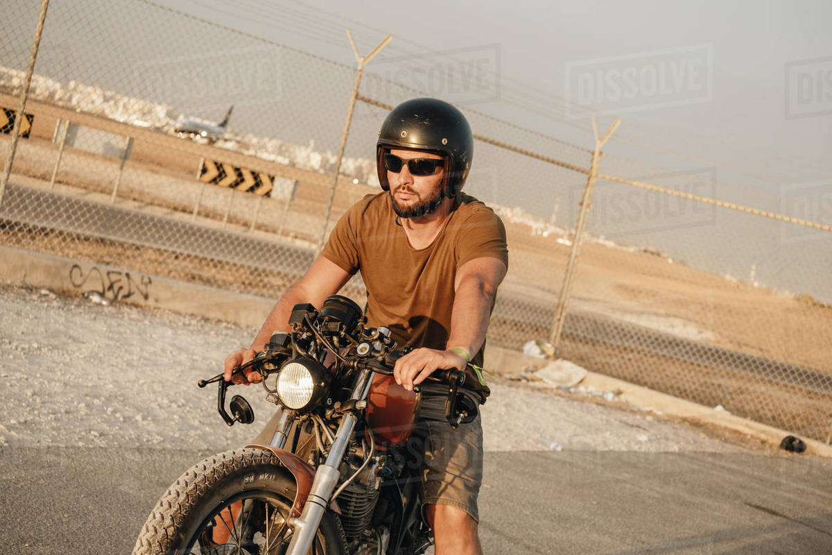 Strong man driving motorcycle - Stock Photo - Dissolve