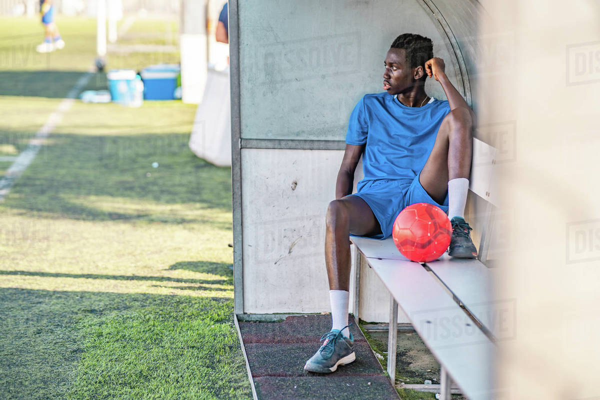 Black football player resting on bench - Royalty-free Stock Photo ...