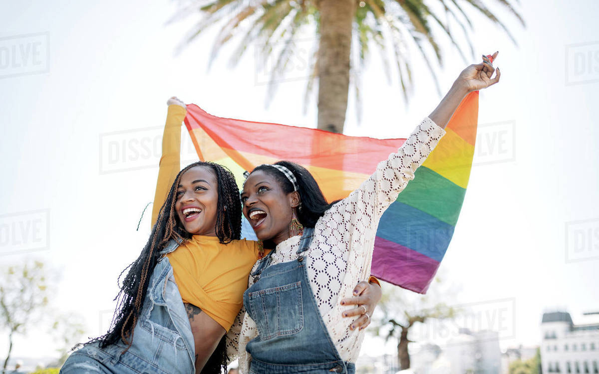 Low angle of delighted African American females in love hugging on ...