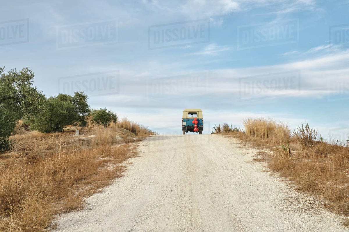 Lonely car driving along rural sandy roadway in summer on background of ...