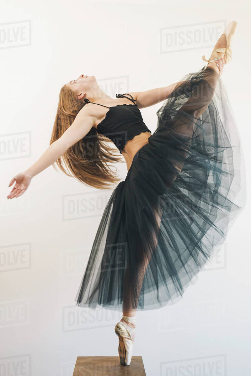 Side view of graceful female ballet dancer in pointe shoes and black ...