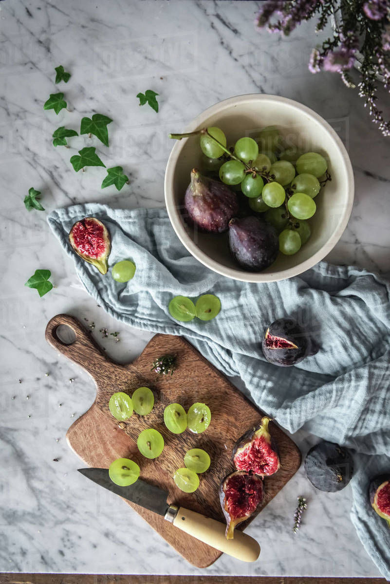 Top view of delicious grapes and figs arranged on marble table with ...