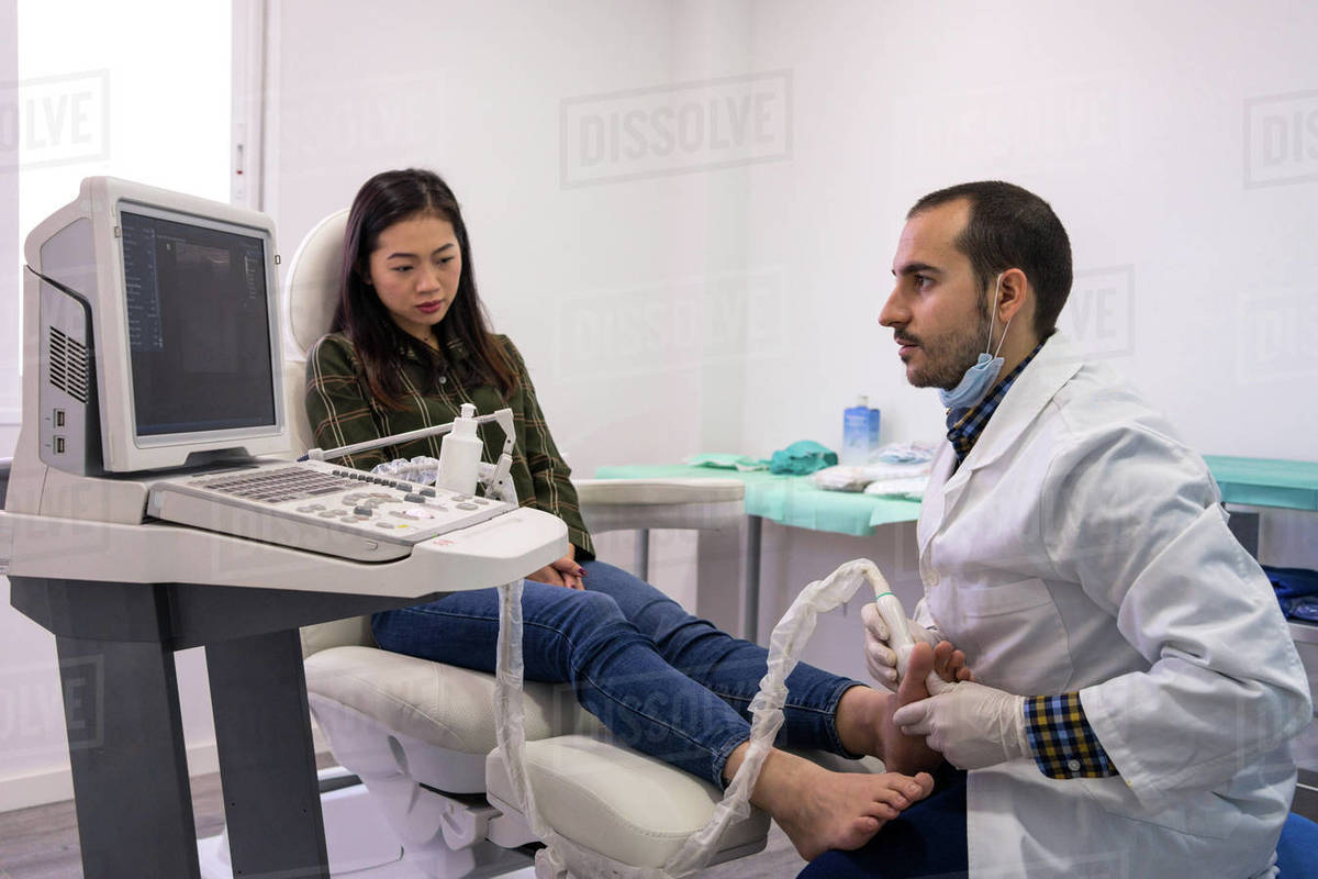 Podiatry doctor using ultrasound scanner - Stock Photo - Dissolve
