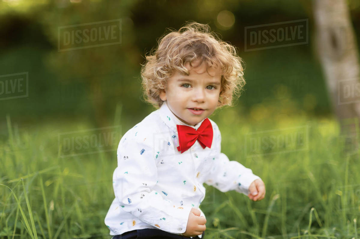 Overjoyed male child having fun in green park - Stock Photo - Dissolve
