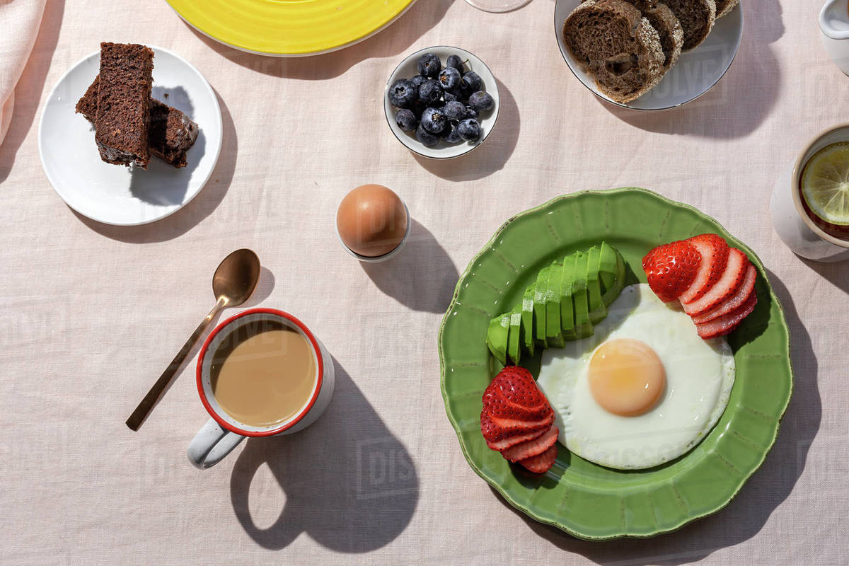 Homemade full healthy breakfast in sunlight with eggs, avocado ...