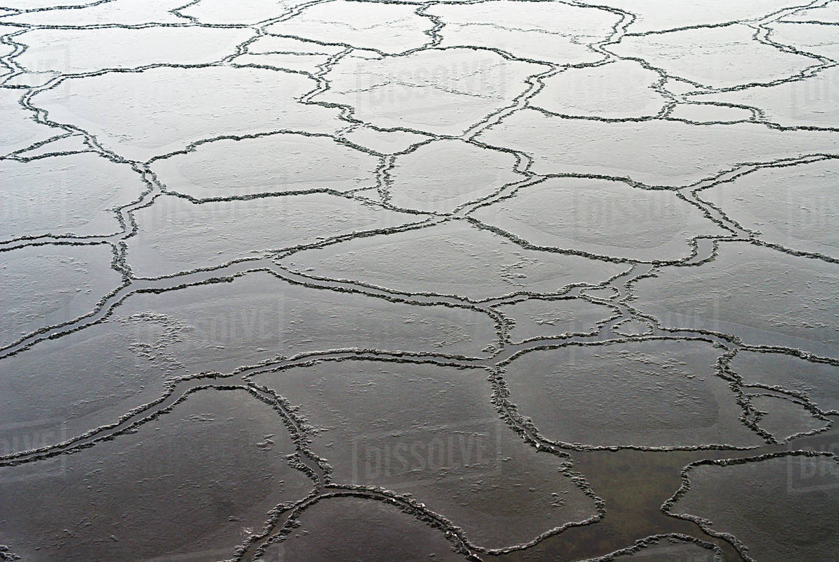 From above closeup of beautiful surface of ice on water of calm pond in ...
