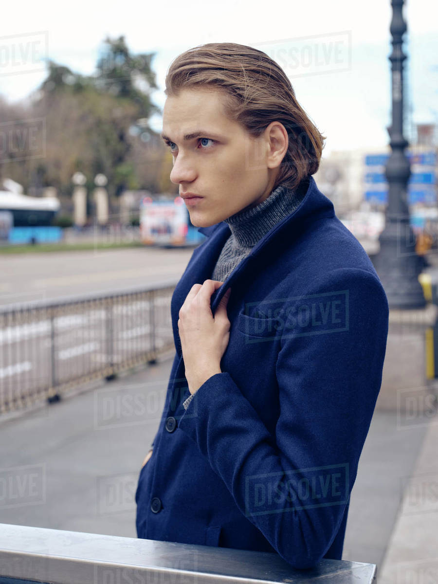 Side view of stylish young male with trendy hairstyle dressed in ...
