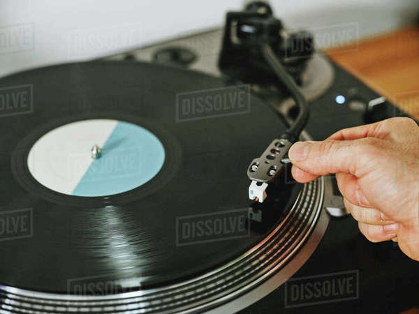 From above cropped person hands adjusting a contemporary vinyl record ...