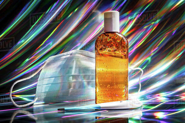 Glass of antiseptic liquid and forensic face respirator mask placed ...