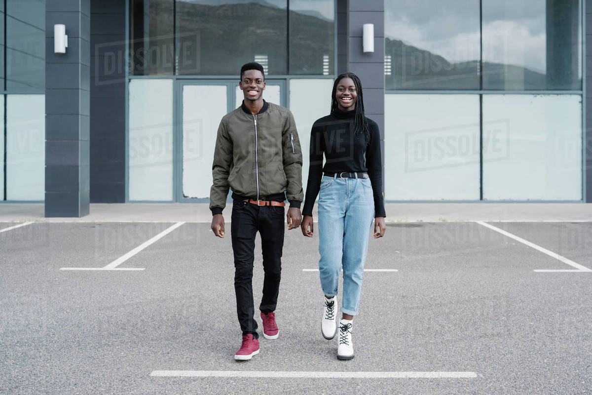 Happy black couple walking outside modern building - Royalty-free Stock ...