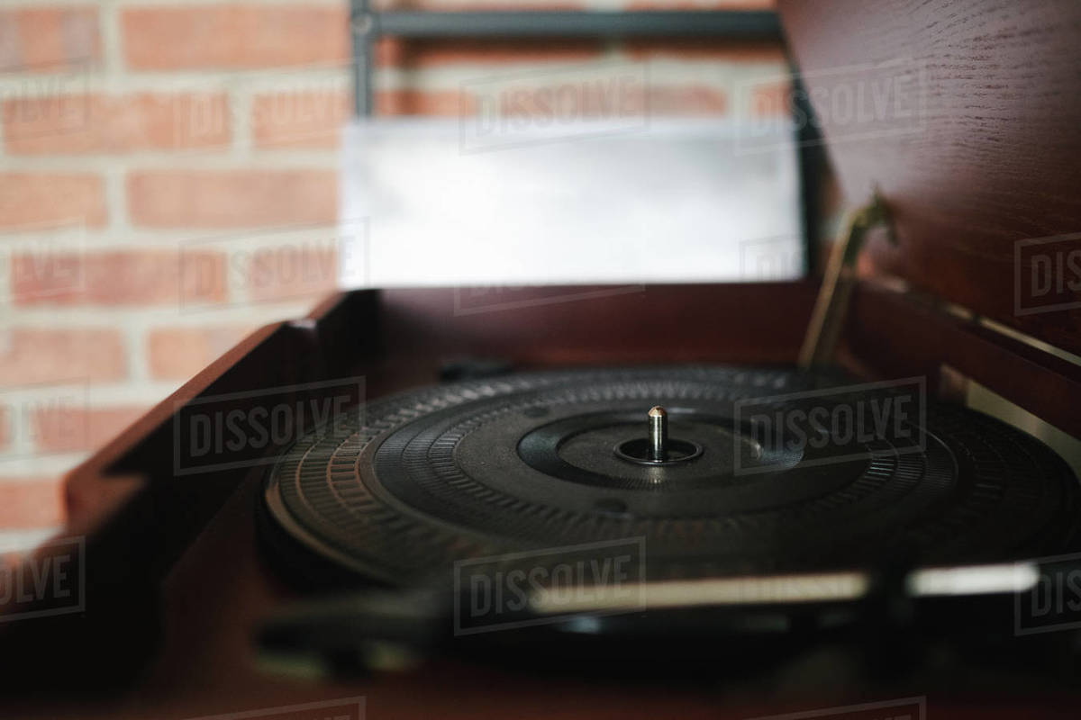 Closeup of record player with wooden lid having black vinyl record ...