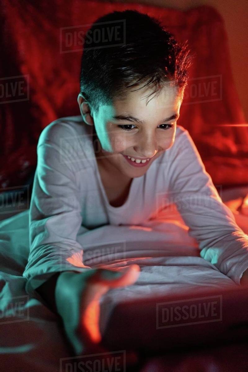 Delighted boy watching cartoon on tablet - Stock Photo - Dissolve
